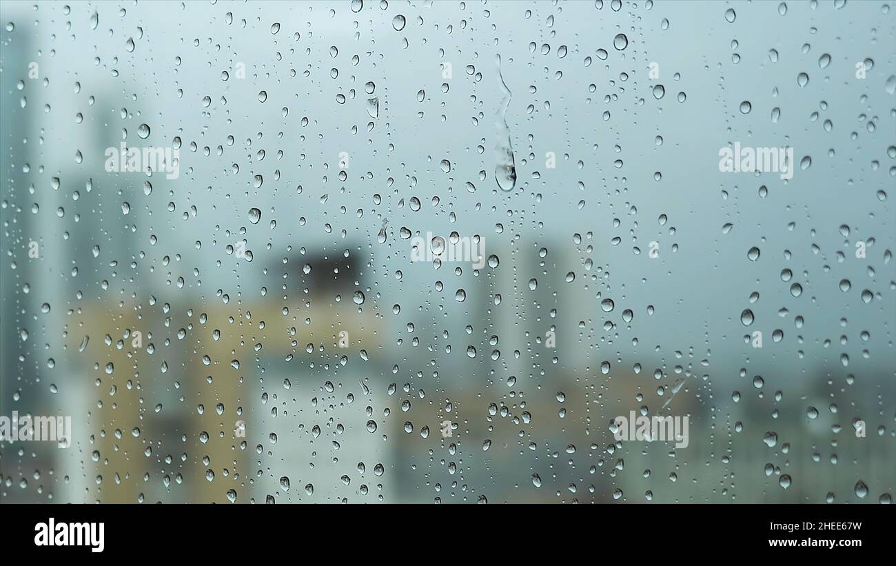 Close up of a glass window on a rainy day with big drops on blurred ...