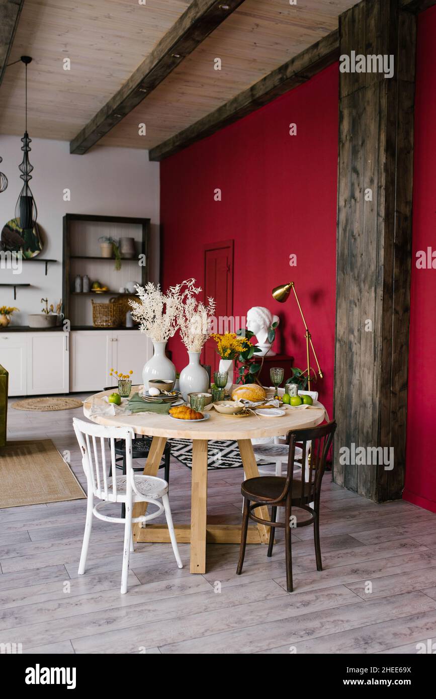 Round dining table with different chairs in the interior of a modern ...