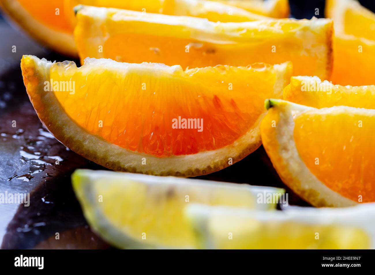 slices of orange, and emon, on black background Stock Photo - Alamy