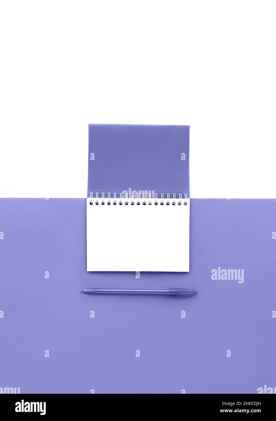 Top view of opened spiral notepad with pen toned in trendy color of ...
