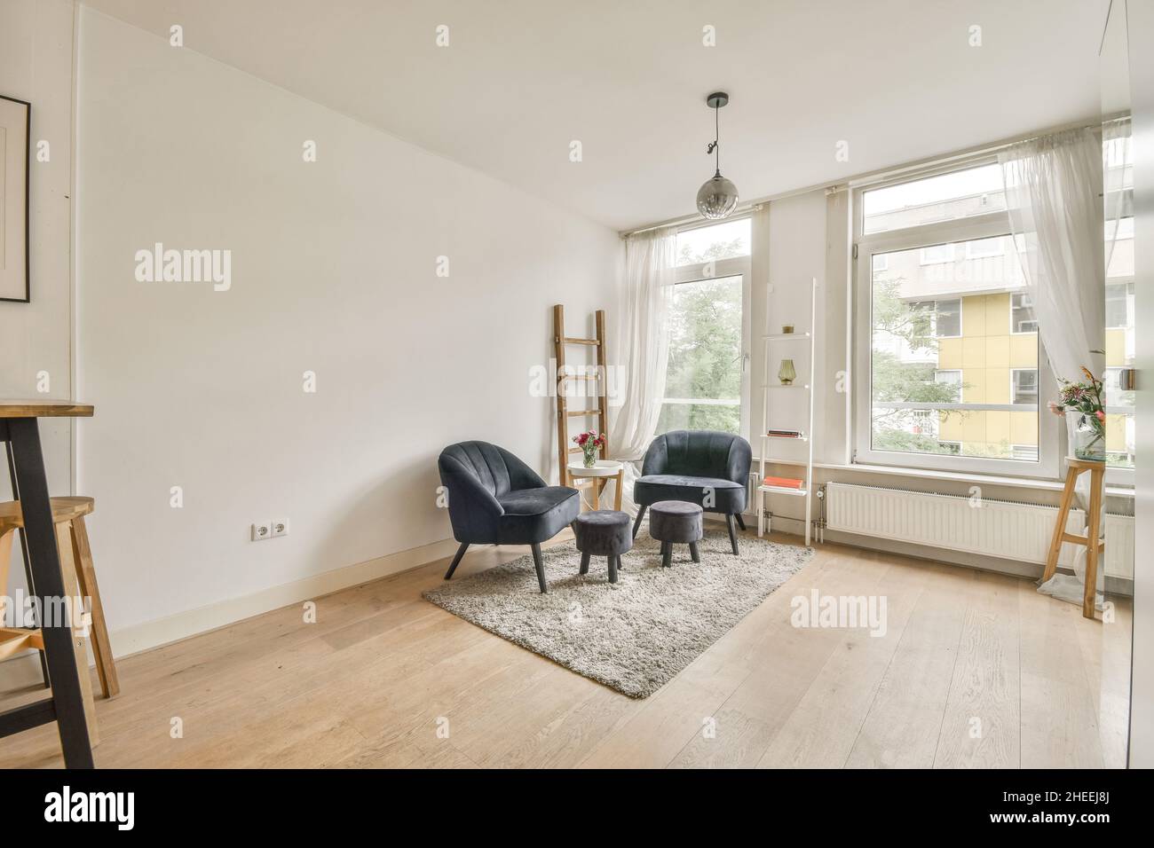 Interior of spacious light living room with small chairs and ...