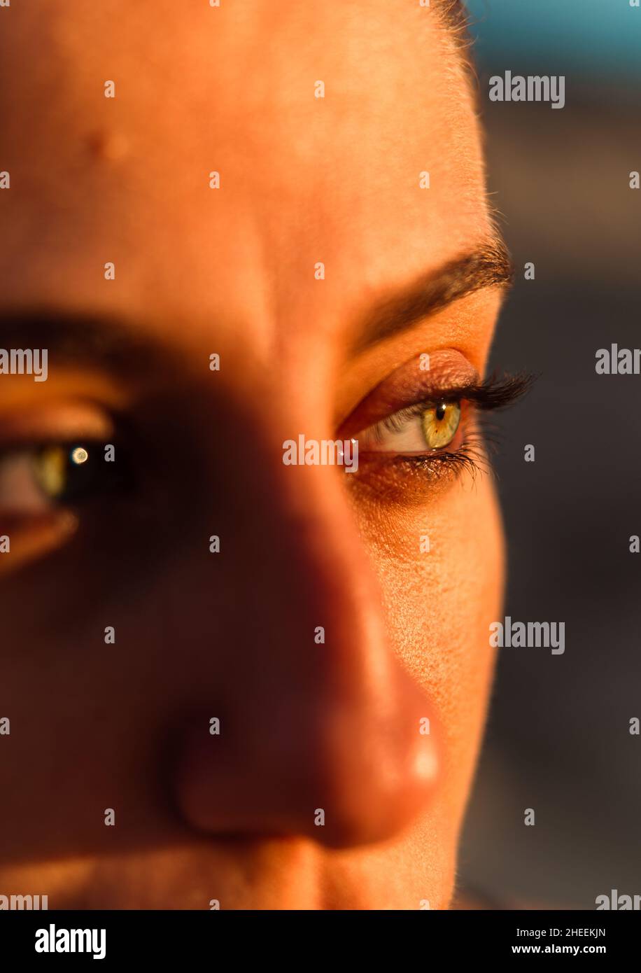 Closeup of crop half face of young Woman with light green eyes looking ...