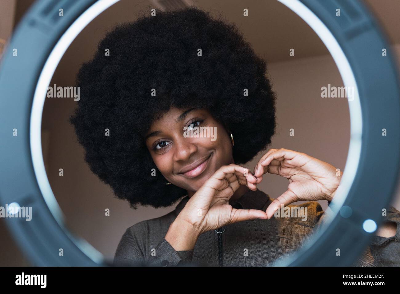 Cheerful African American female blogger with Afro hairstyle making ...