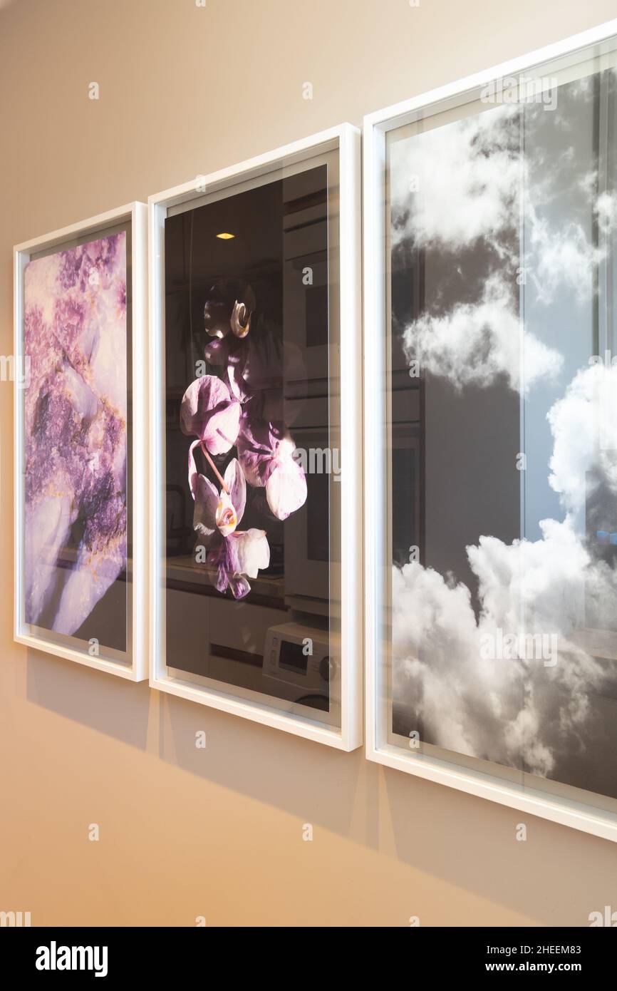 Row of creative illustrations under glass in frames decorating wall of ...