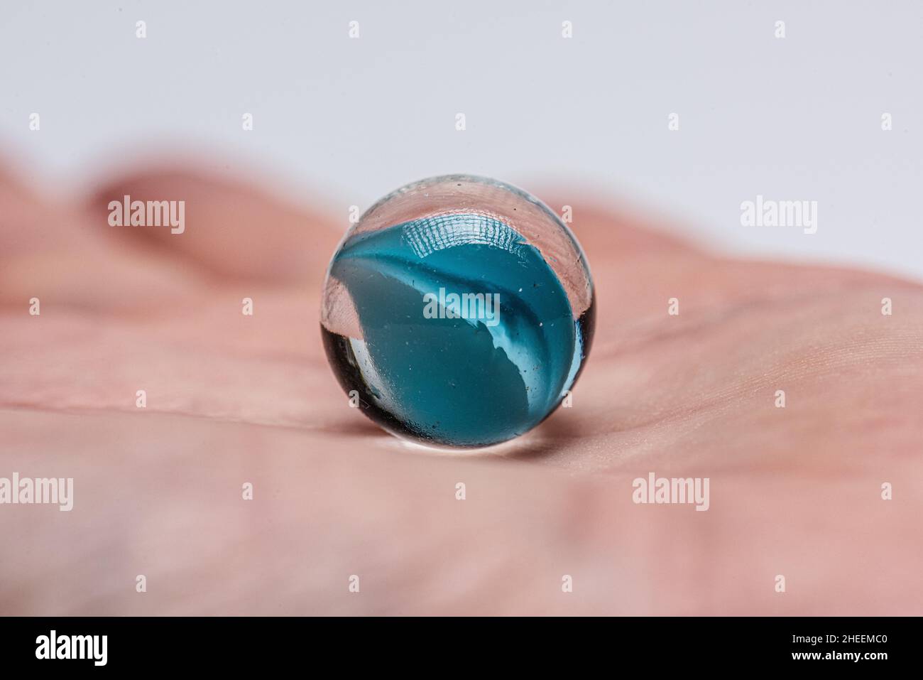 Blue glass marble in a hand Stock Photo - Alamy
