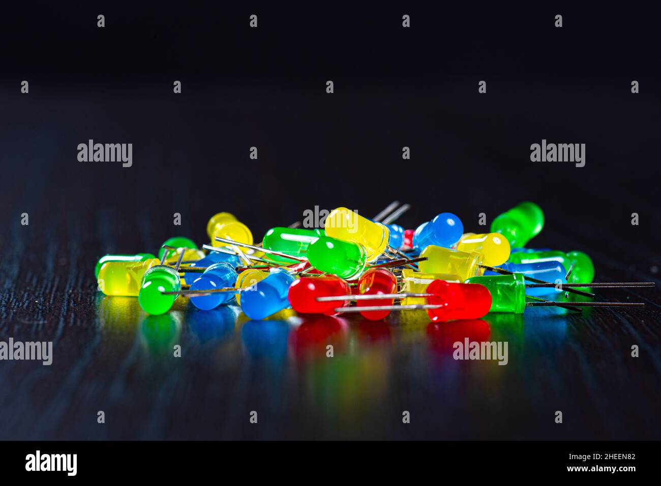 Assortment of yellow, red, green and blue LED diodes in a black table ...