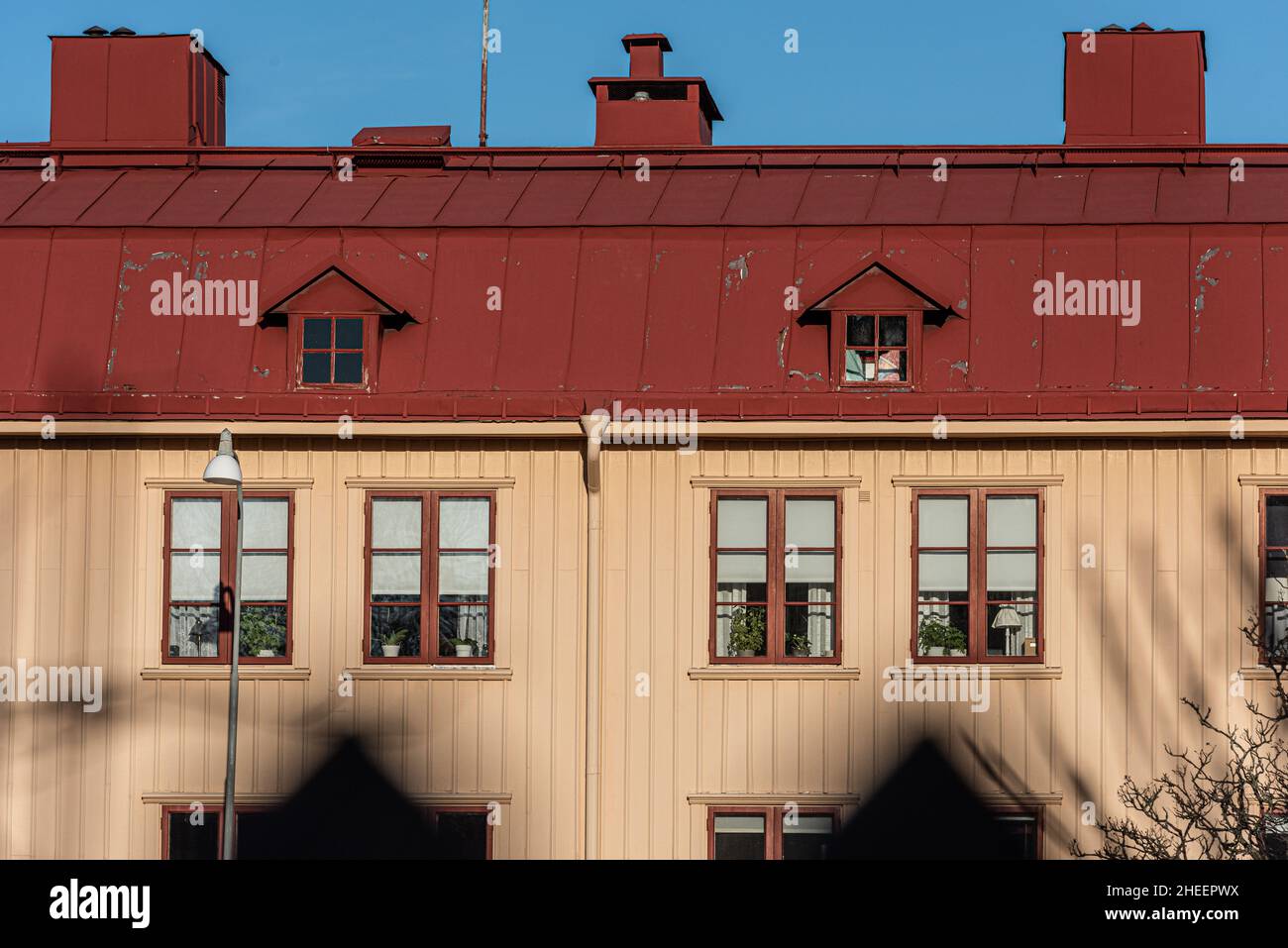 Facade of a beige wooden apartment building with red roof Stock Photo ...
