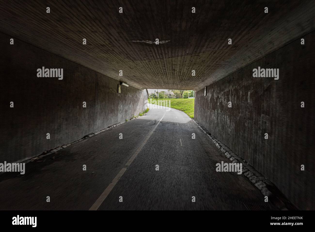A dark bike underpass with a curve in the end of the tunnel Stock Photo ...
