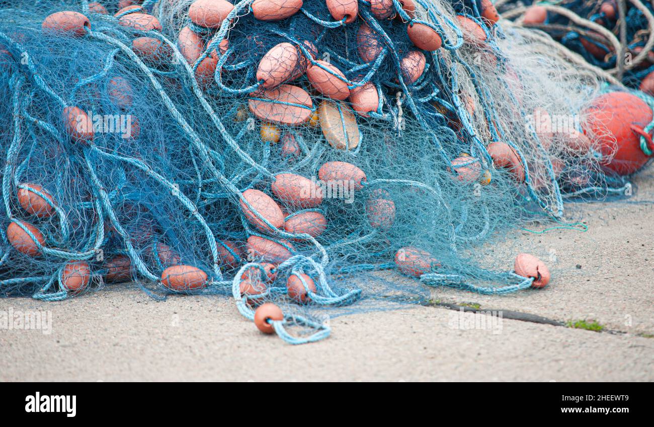 A pile of fishing nets on the ground Stock Photo - Alamy