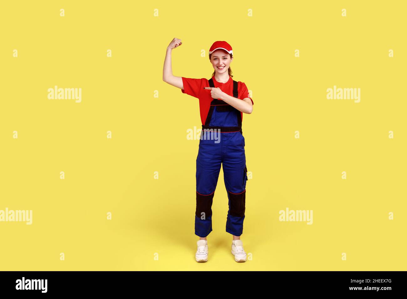 Full length portrait of optimistic woman worker standing with raised ...