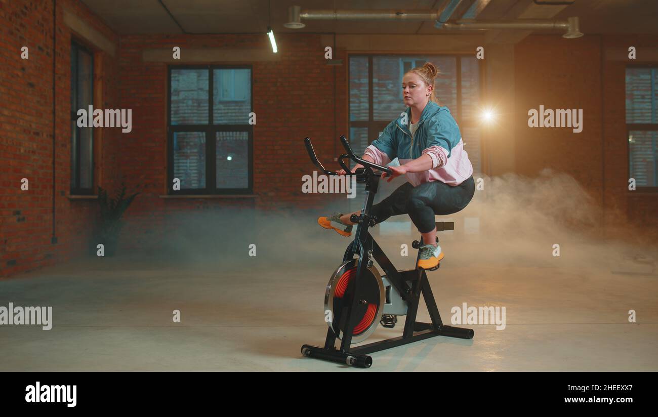 Healthy Caucasian woman exercising workout on stationary cycling ...