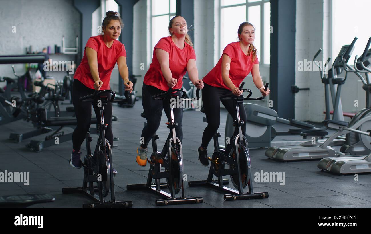 Group of girls performs aerobic training workout cardio routine on bike ...