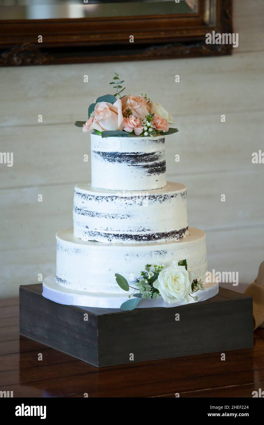 Beautiful three tiered wedding cake with roses and dirty icing Stock ...