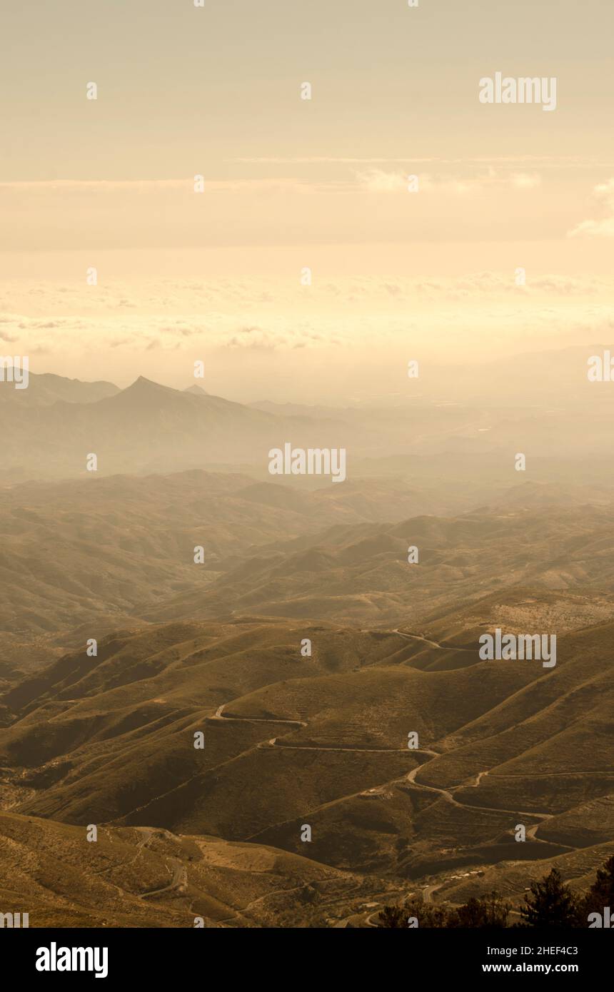 mountains, valleys and gorges of a desert where a desolate path crosses ...