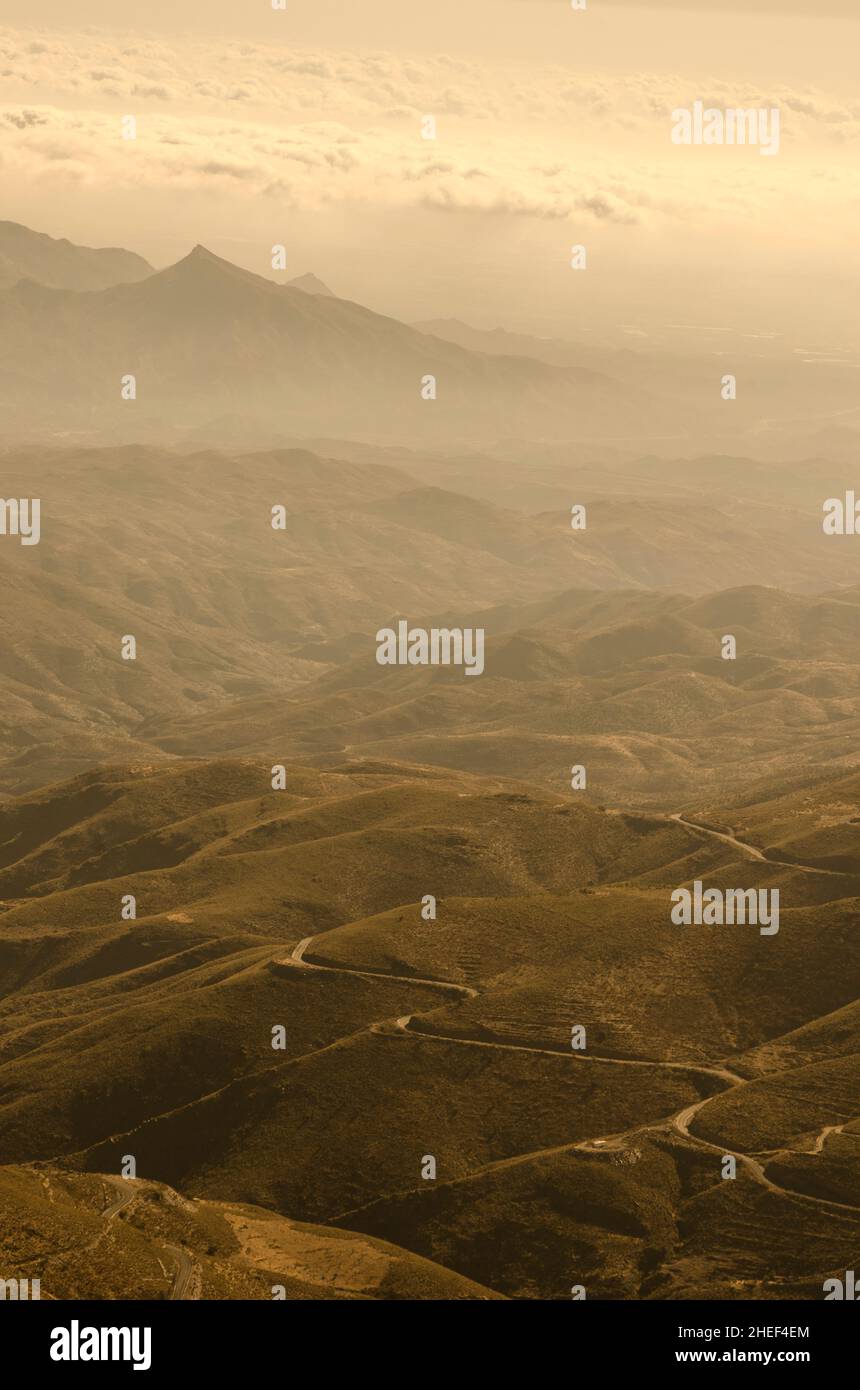 mountains, valleys and gorges of a desert where a desolate path crosses ...