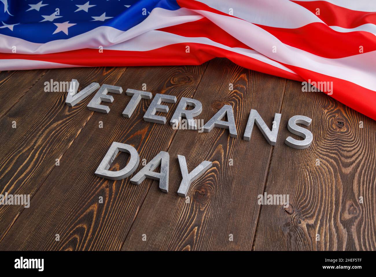 the words veterans day laid with silver metal letters on wooden board ...