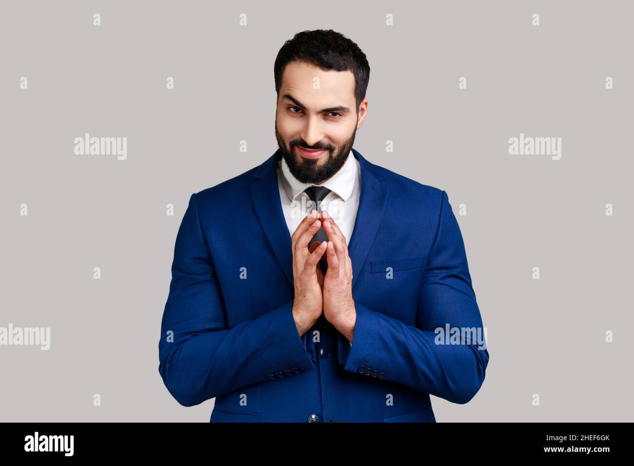 Cunning bearded man clasping hands and planning evil tricky prank or ...