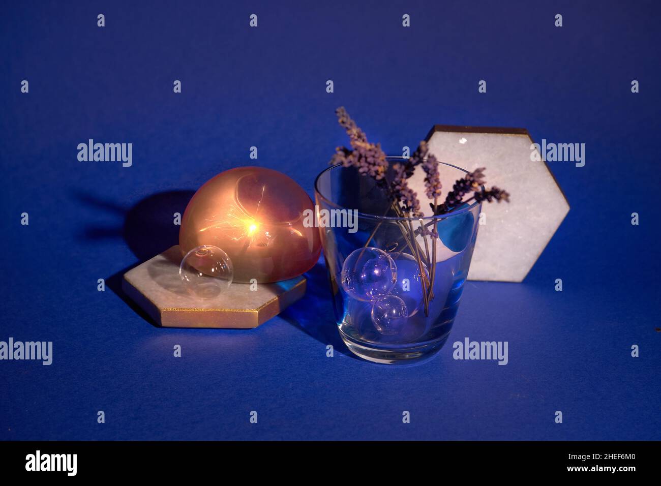 Dry lavender in glass, magic light with sparkles and orange glow. Dark ...