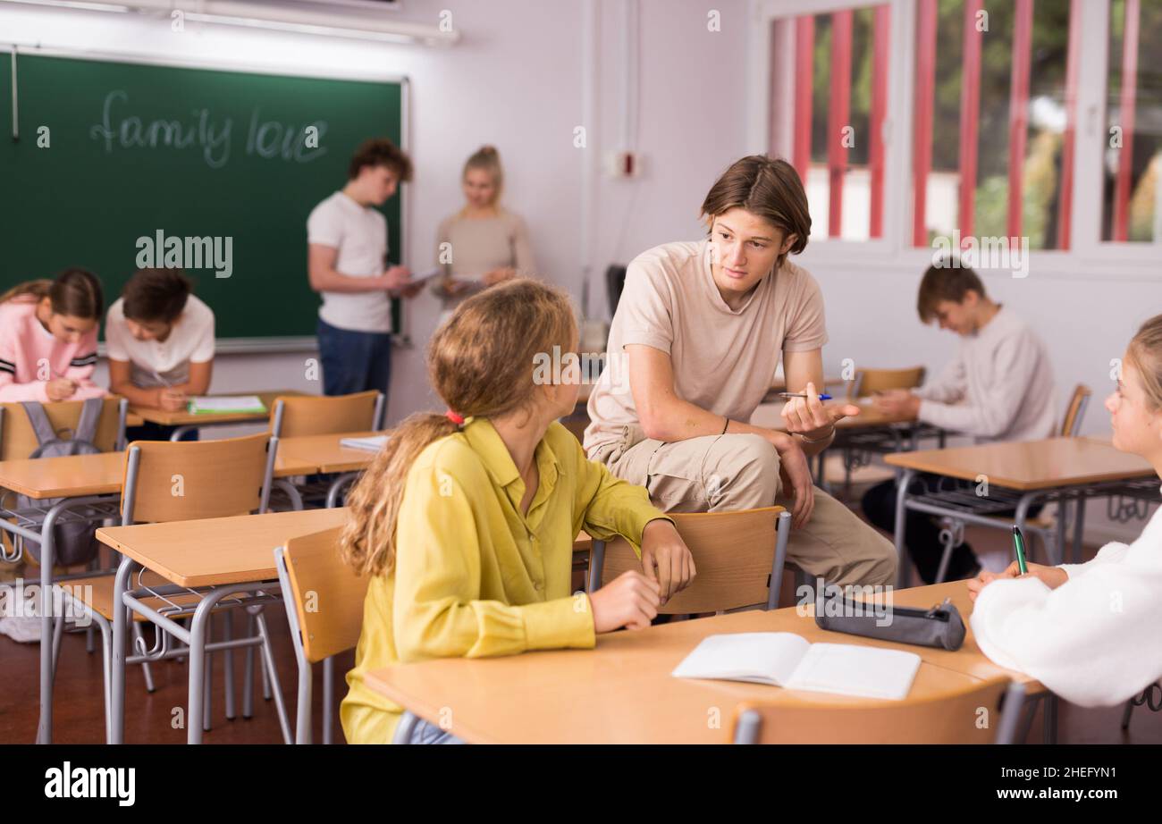 Teenage school pupils talking during break in classroom Stock Photo - Alamy
