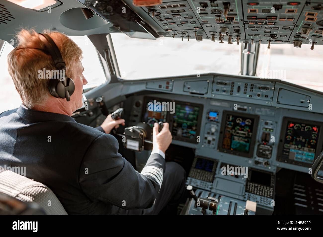Male pilot controlling airplane flight from cockpit Stock Photo - Alamy