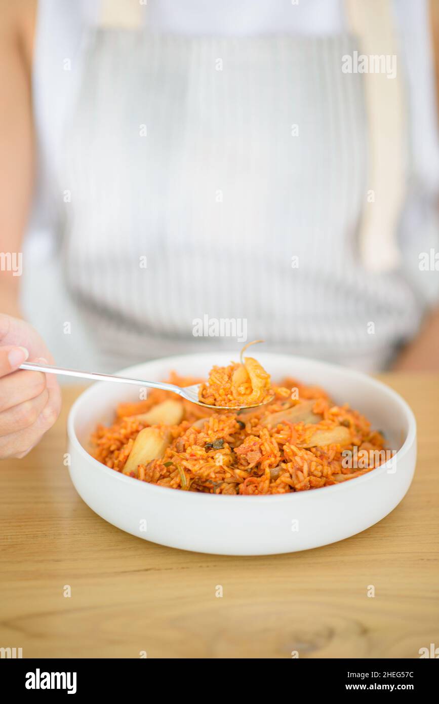 A woman is scooping her homemade kimchi fried rice Stock Photo - Alamy