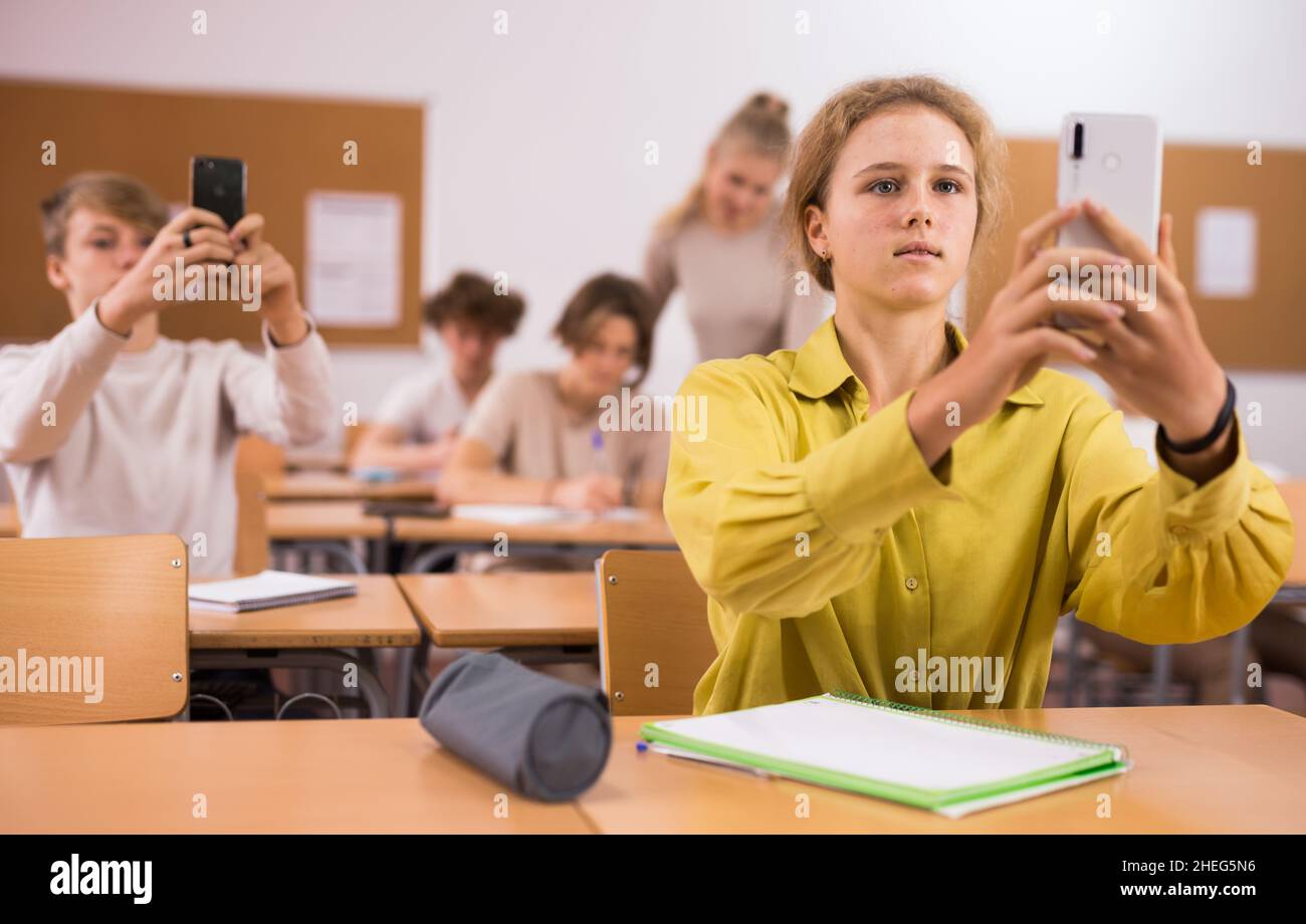 Classmates using their smart phones heavily during classes Stock Photo ...