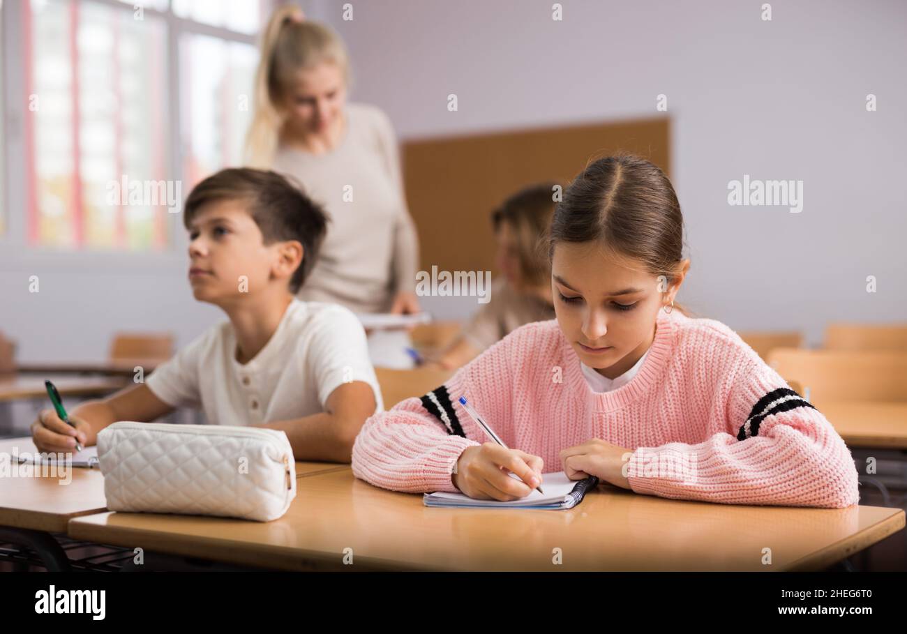 Group of school kids and teacher during lesson Stock Photo - Alamy