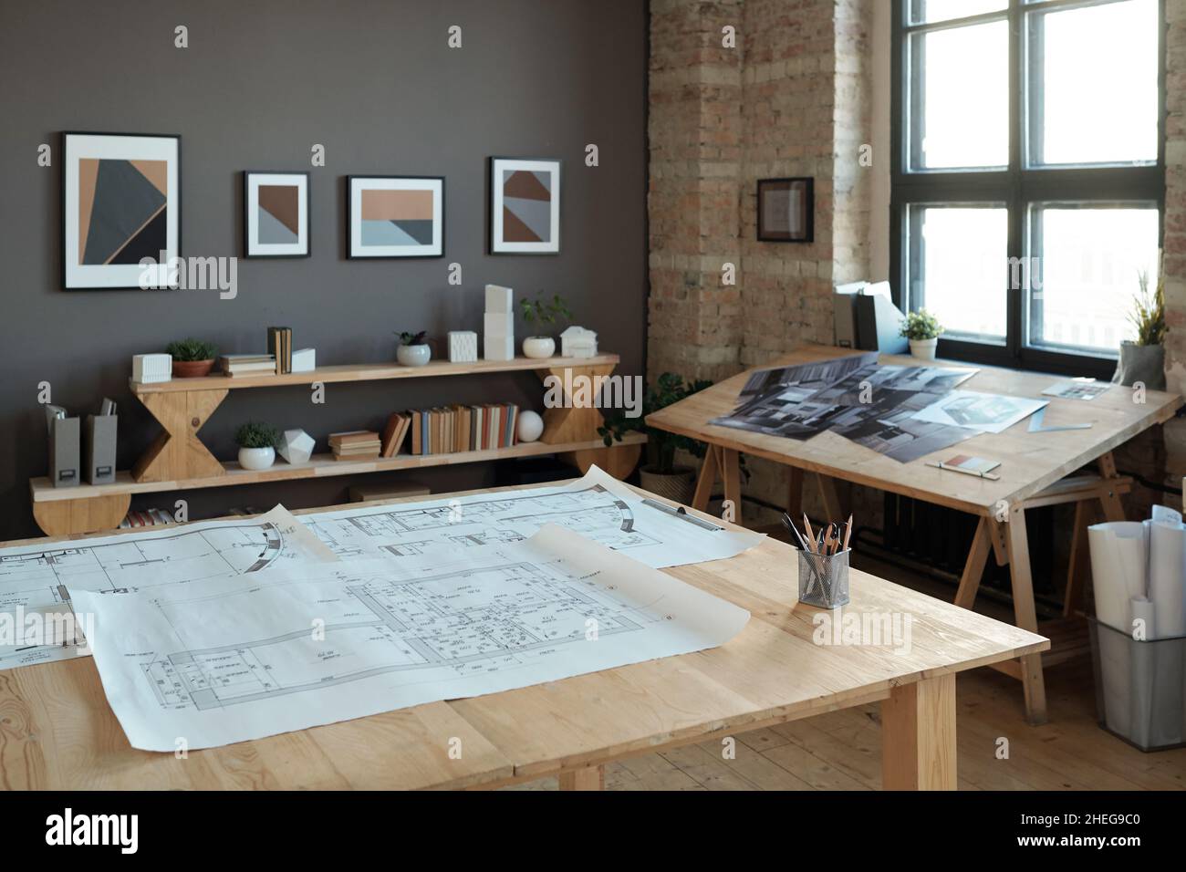 Group of blueprints with architectural sketches on large wooden table ...