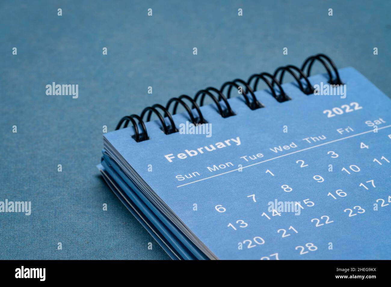 February 2022 - spiral desktop calendar against textured paper, time ...