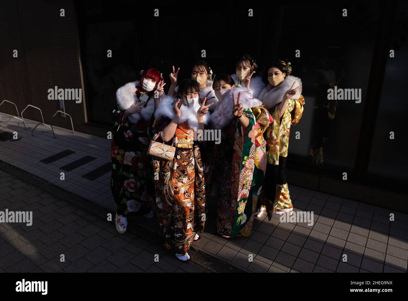 Young women dressed in Furisode pose for a picture near Yokohama Arena ...