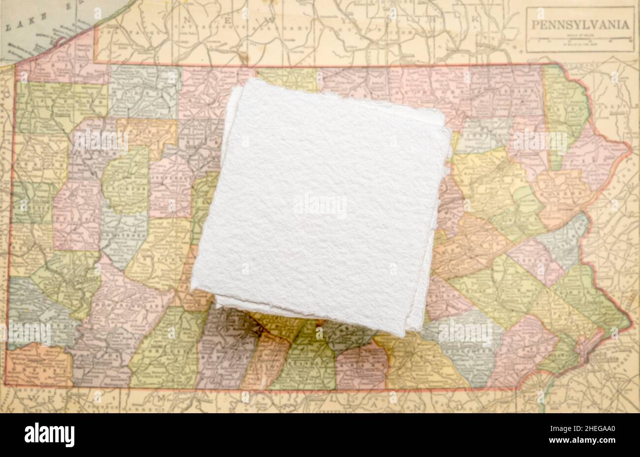 small, blank, square sheet of rough handmade paper floating over ...