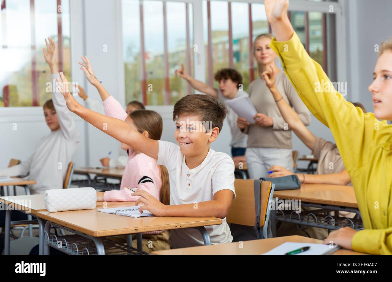 Pupils raising hands during lesson Stock Photo - Alamy