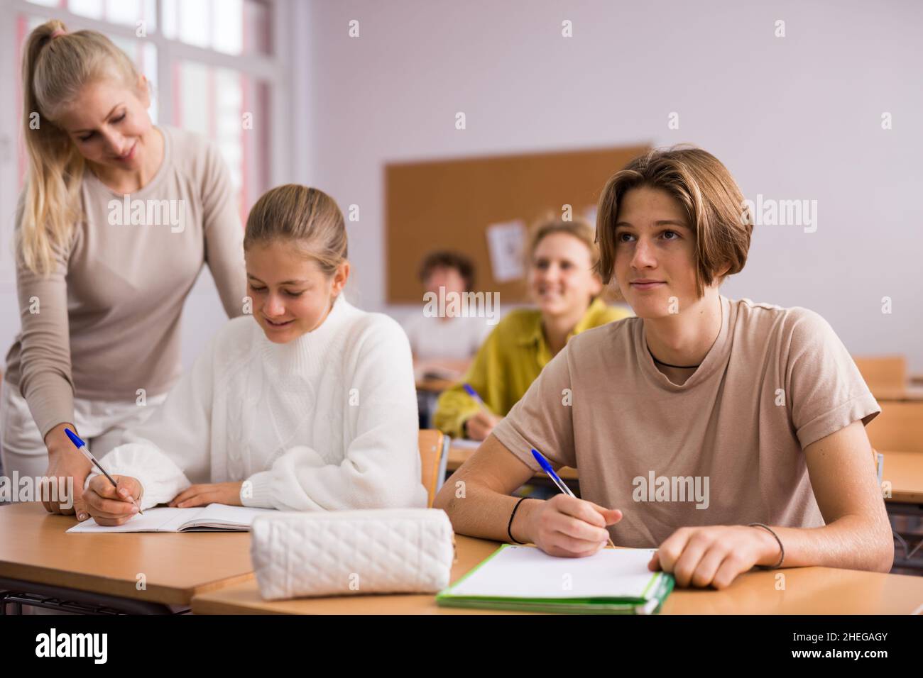Group of school kids and teacher during lesson Stock Photo - Alamy