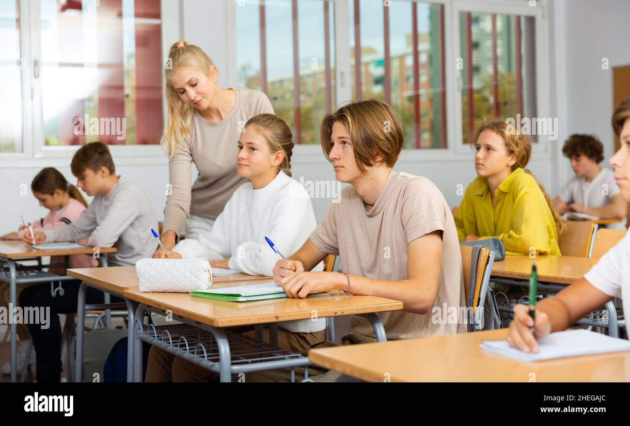 Group of school kids and teacher during lesson Stock Photo - Alamy