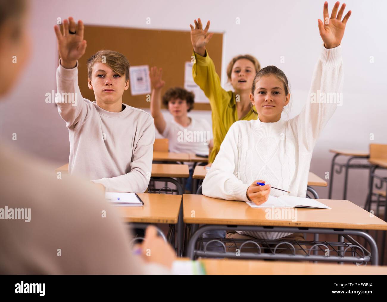 Friendly schoolchildren raise their hand to answer during lesson Stock ...