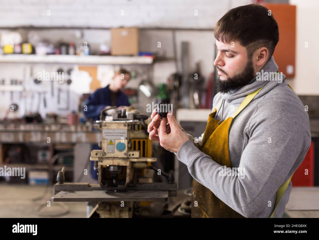 Metalworker checking metal part made on milling machine Stock Photo - Alamy