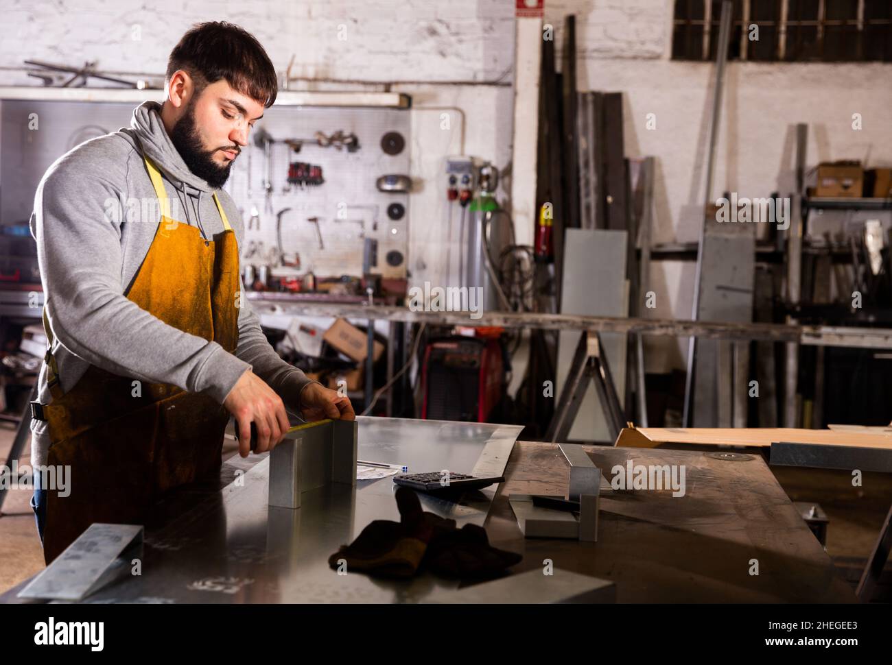 Man measuring metal structures in workshop Stock Photo - Alamy