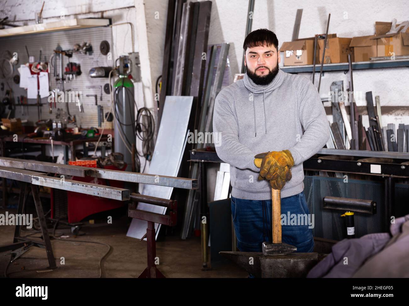 Man mechanic working with hand hammer in workshop Stock Photo - Alamy