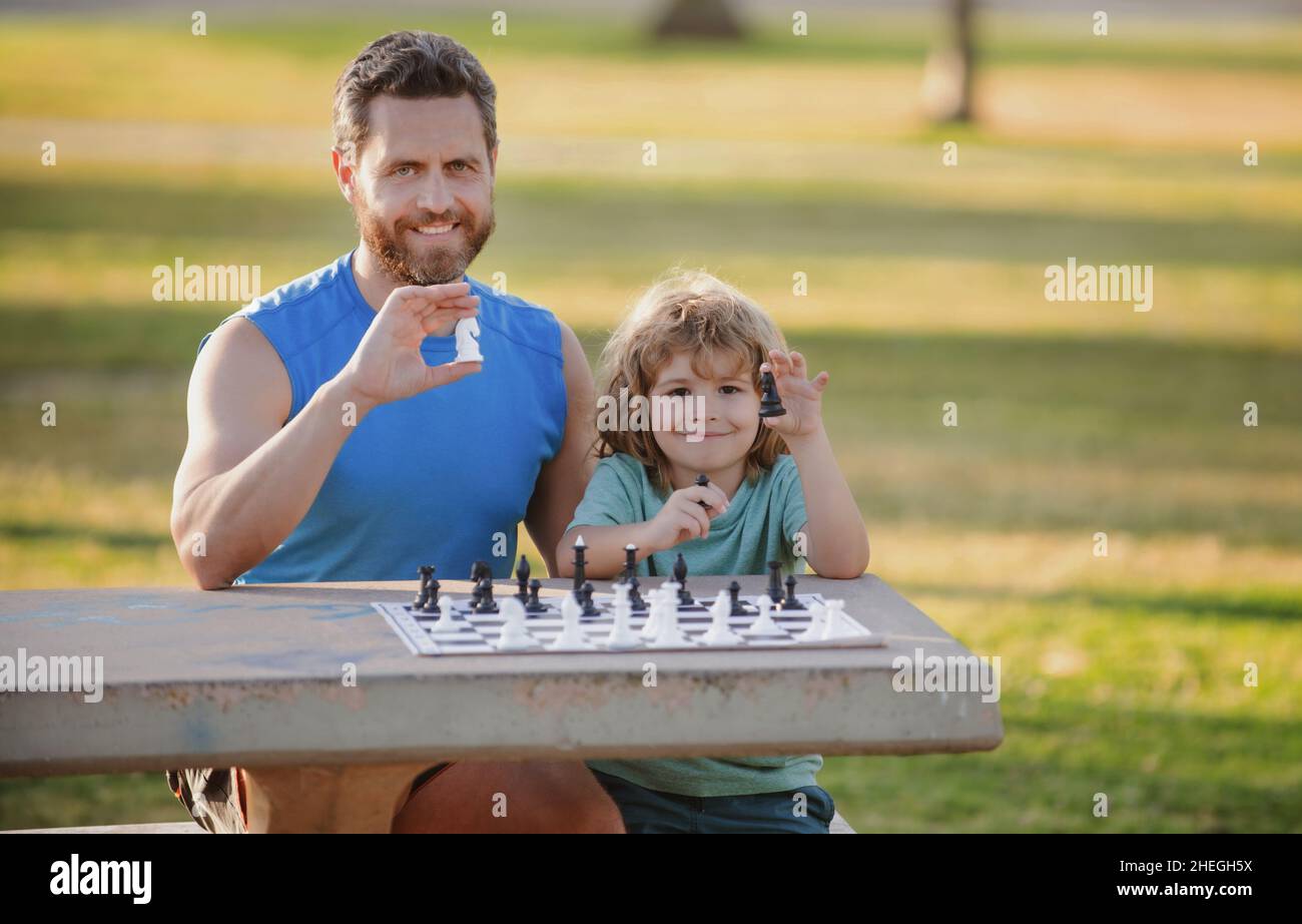 Father and son playing chess spending time together in park. Kid play ...