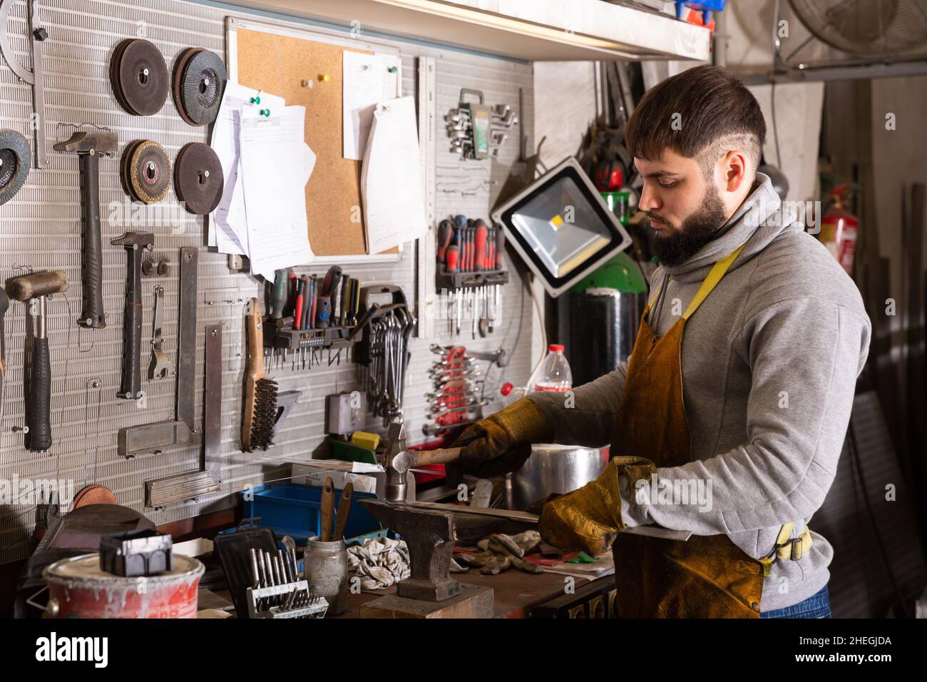 Factory worker handles part on bench vise Stock Photo - Alamy
