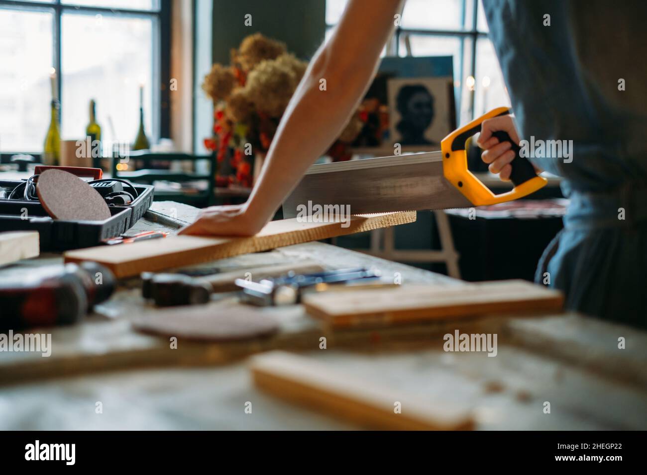 Woman working with wood in workshop. Measuring plunk, drilling holes ...