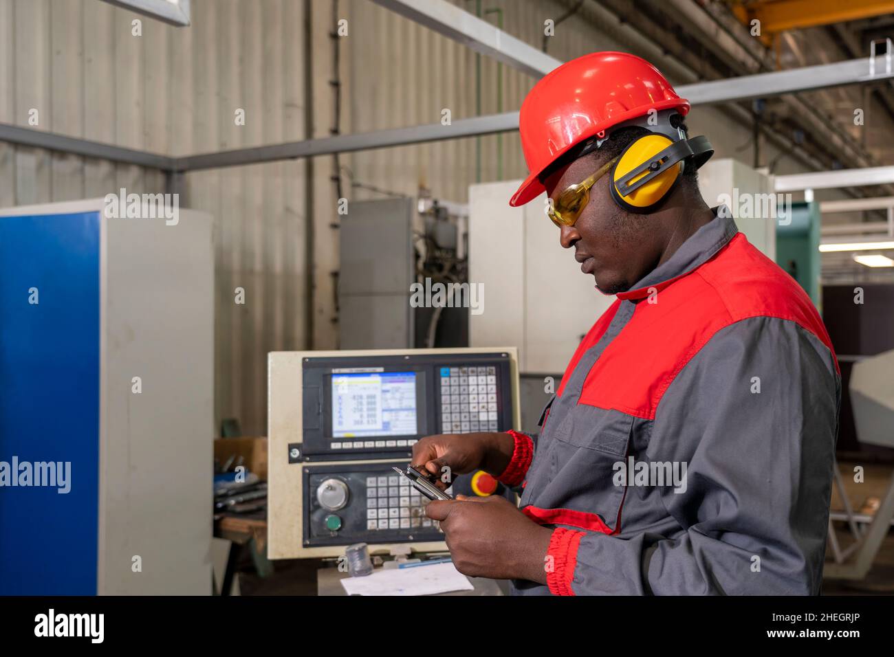 Waist Up Portrait Of Machine Operator In Red Helmet, Yellow Safety ...