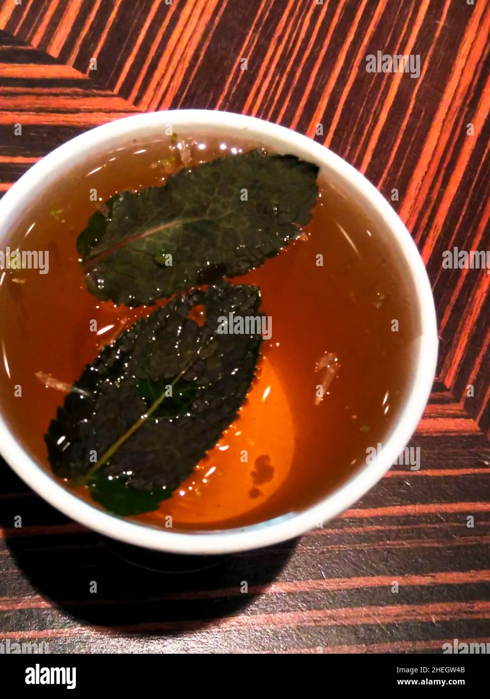 Herbal tea in a paper cup with leaves of fireweed. View from above ...