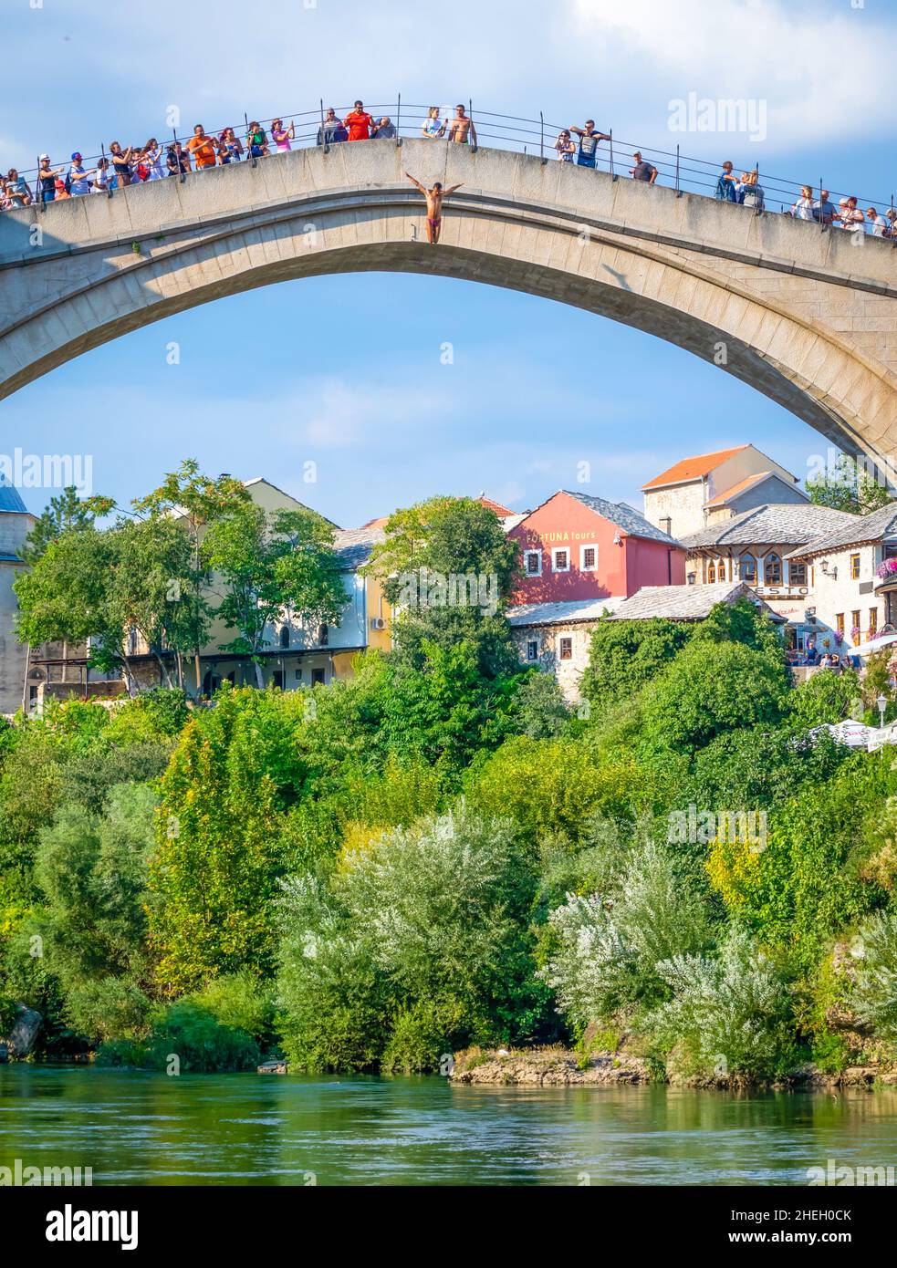 Male person in a swimsuit jumps off the Most Musala bridge to the river ...