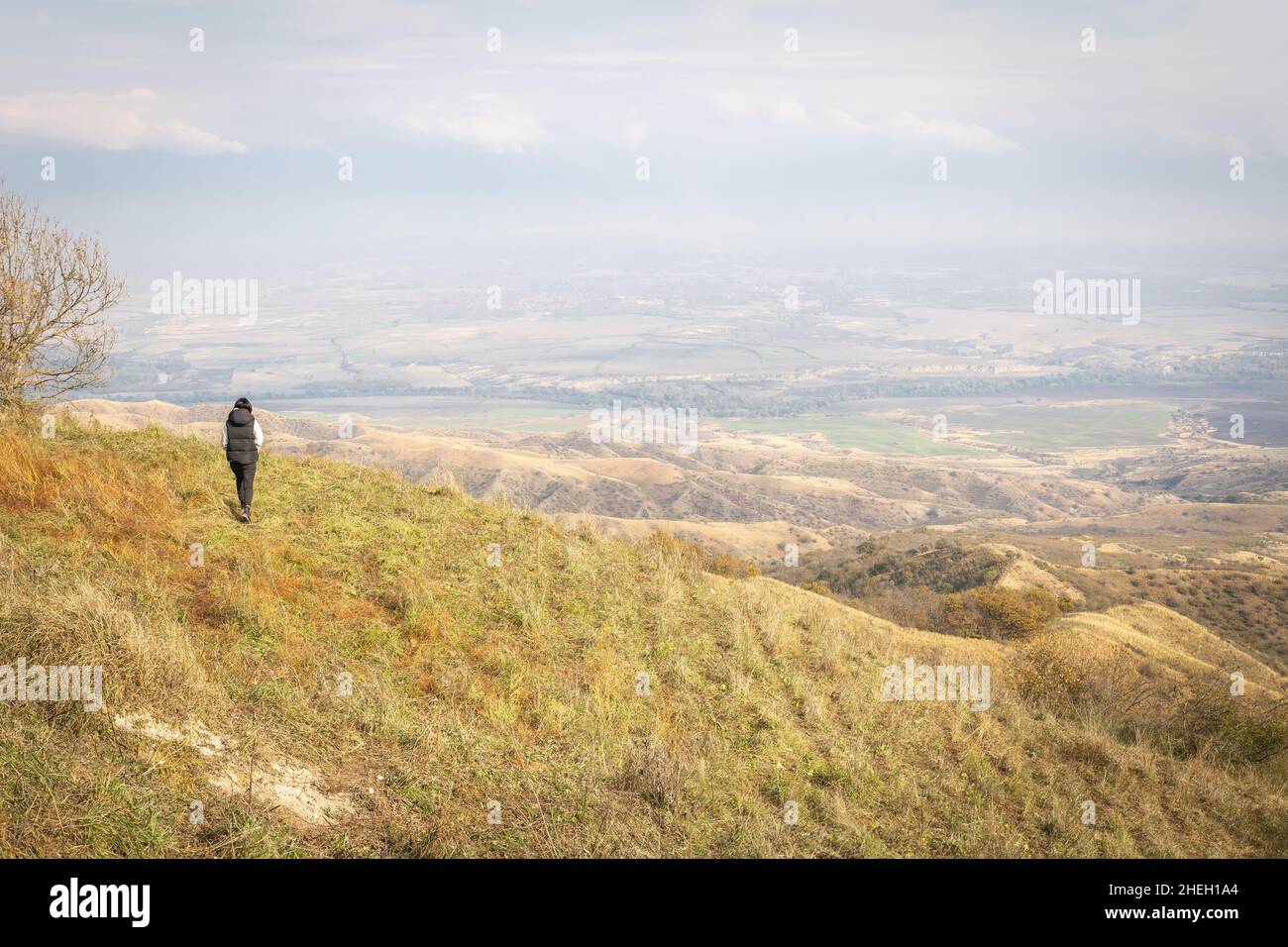 Female person walks on the black mountain with panoramic views of ...