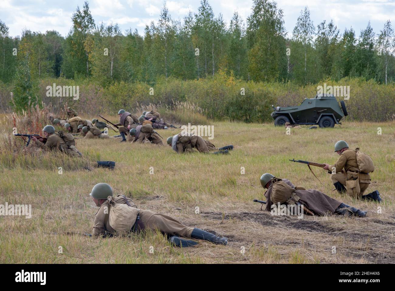 Attack of Soviet soldiers crawling across the field, armored car ...