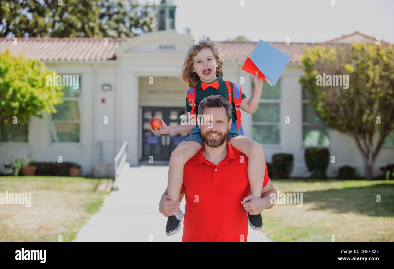 Outdoor school. Parent and pupil of primary school go piggyback ride ...