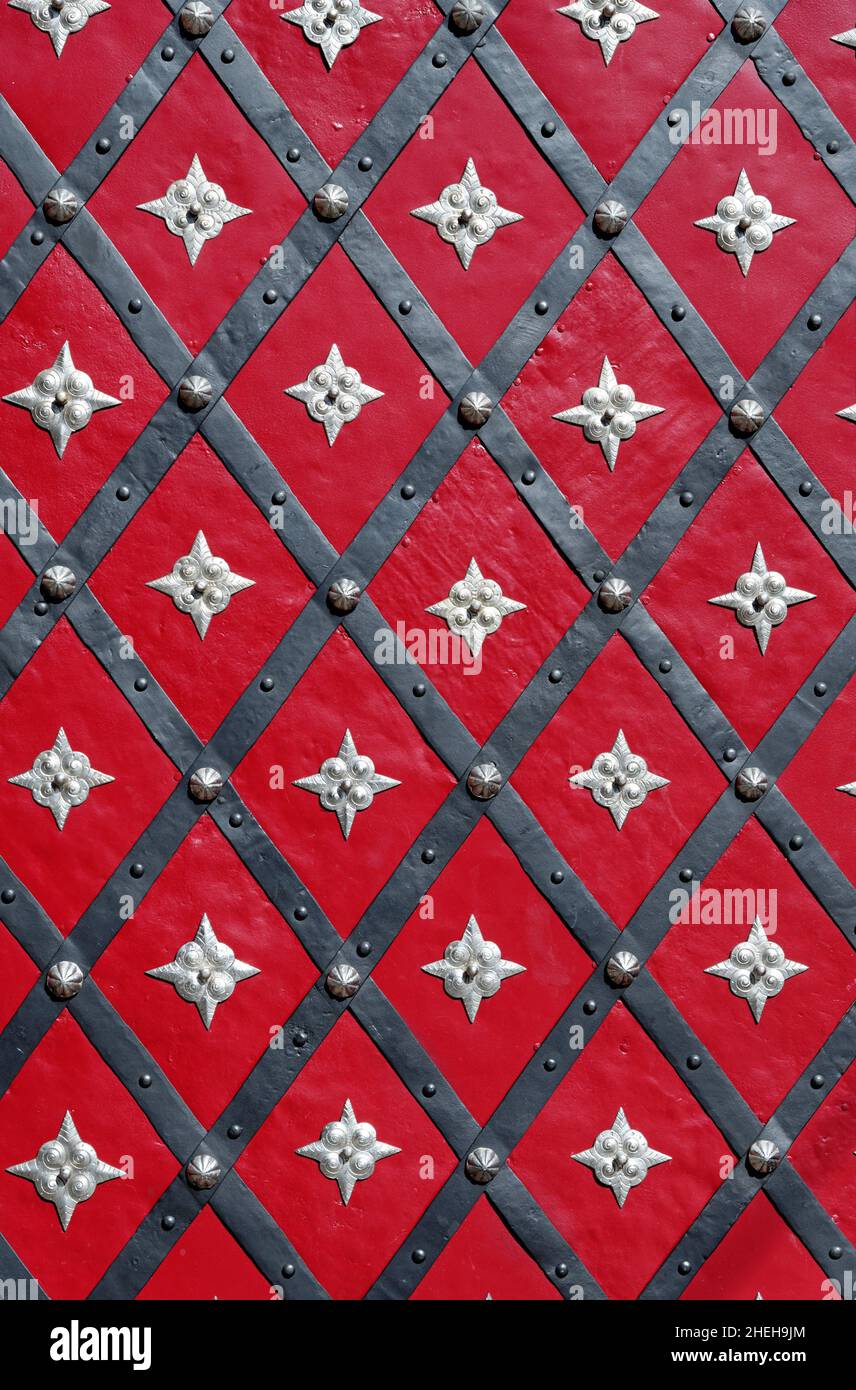 Medieval red door with diagonal iron stripes and silver stars Stock ...