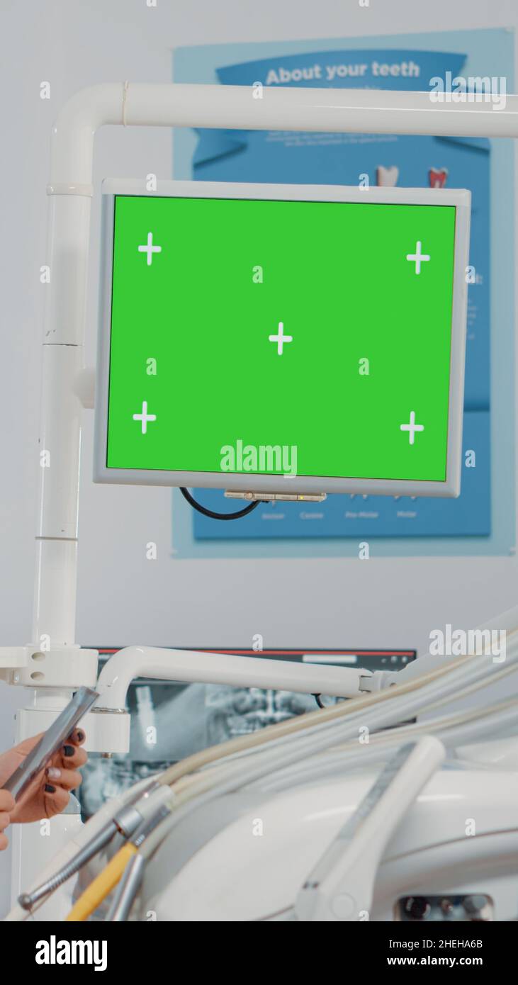 Dentist analyzing horizontal green screen on monitor and radiography of ...