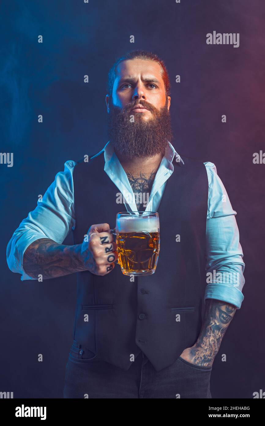Half length of Bearded man who holds mug of beer looking at camera over ...